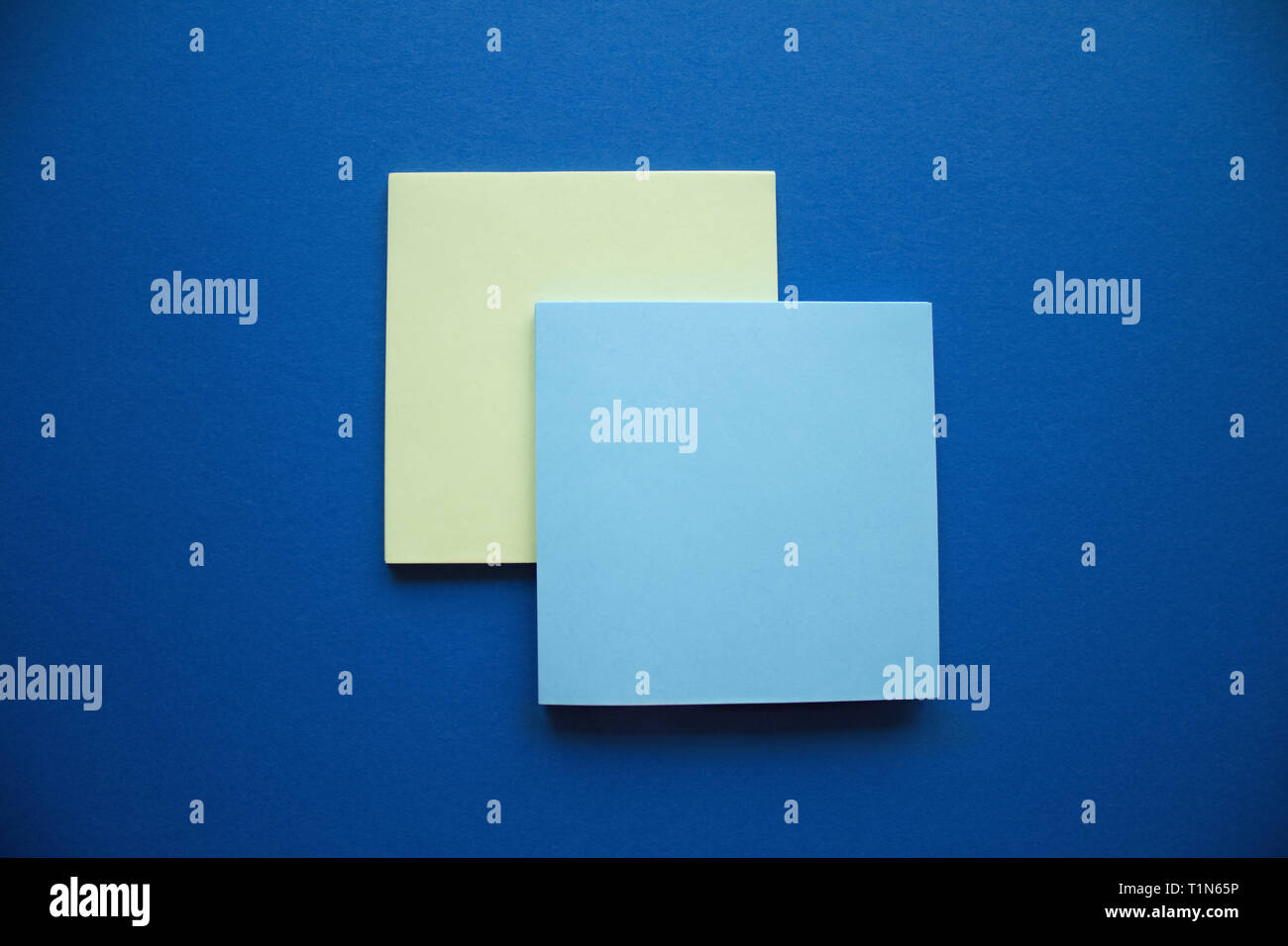 Two blue and yellow square stiker blocks arranged on the dark blue ...
