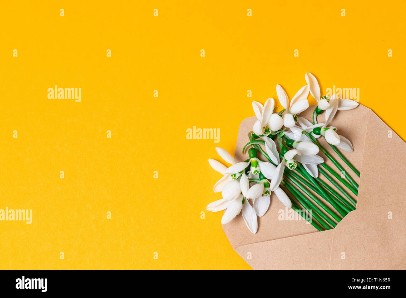 Craft envelope with a spring flower arrangement. Overhead view. Flat ...