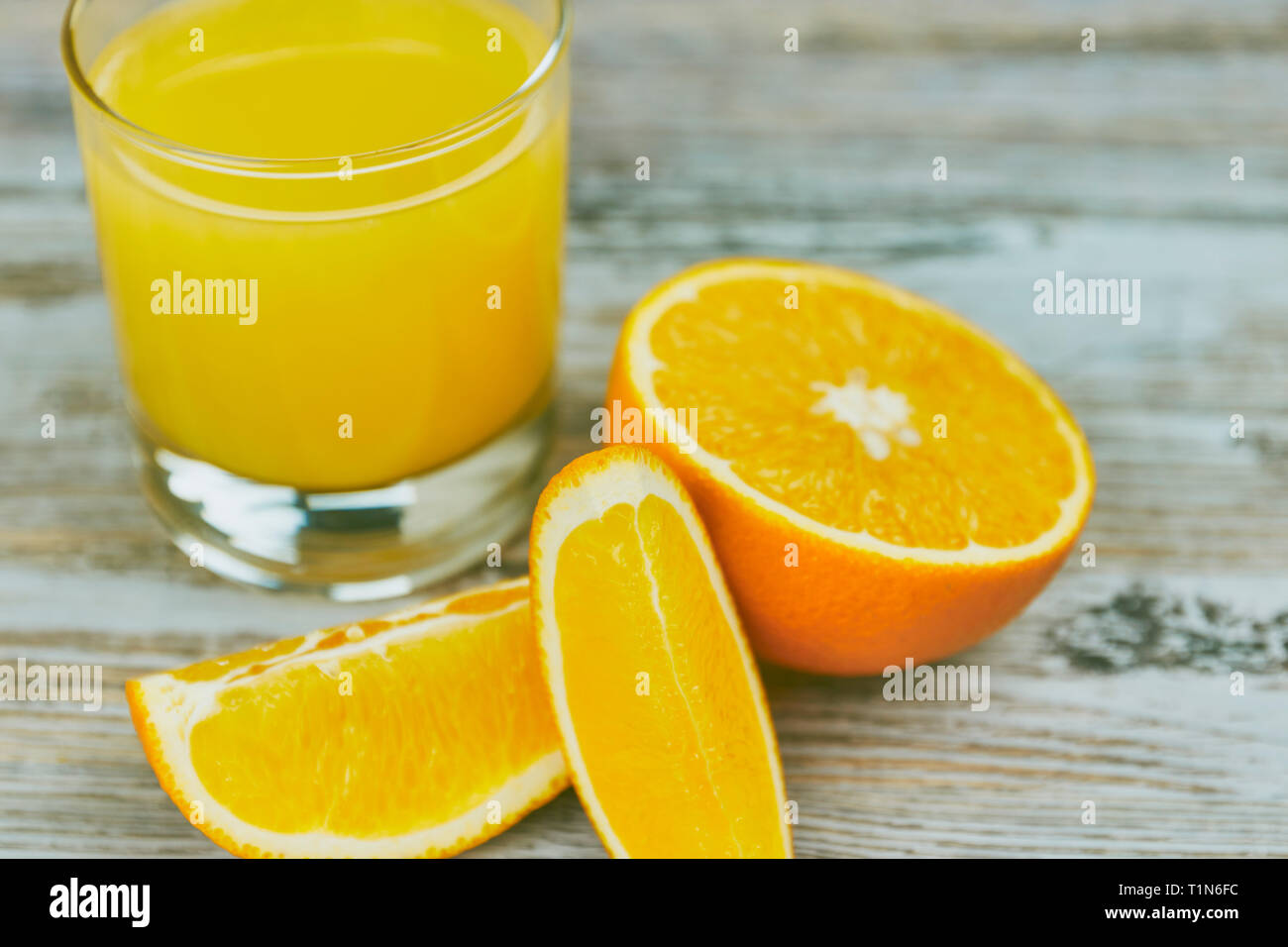a glass of fresh orange juice with fresh citrus fruits on a light ...