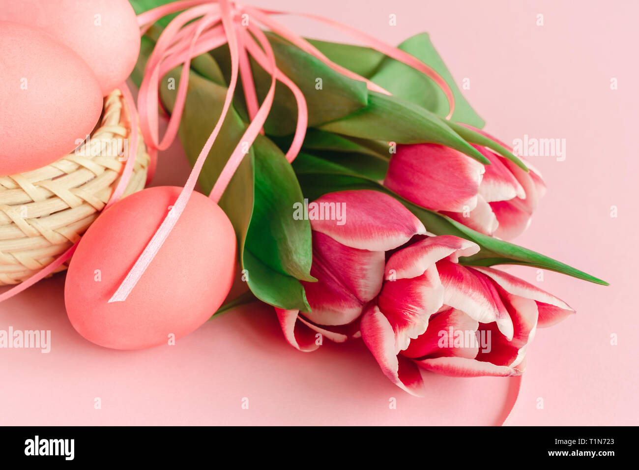Easter composition made of eggs in basket on pastel pink background ...