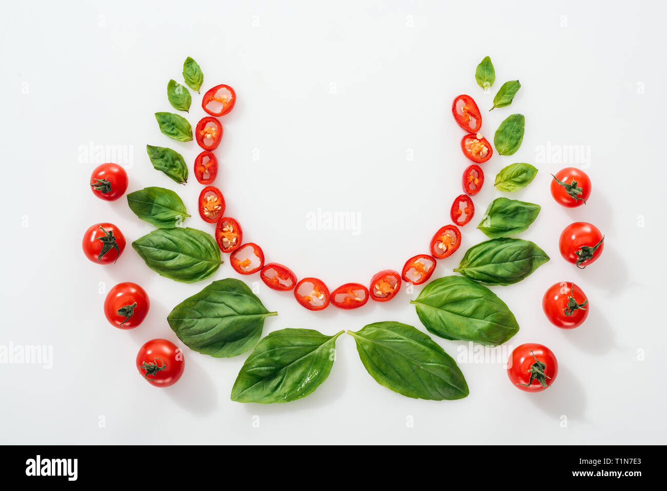 flat lay with cut chili peppers, basil leaves and ripe cherry tomatoes ...
