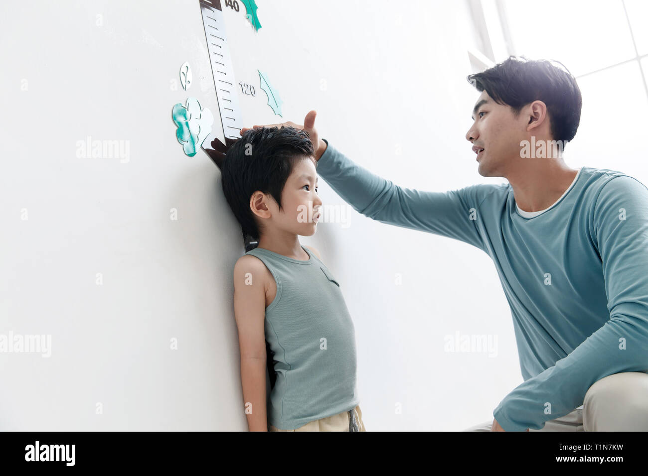 Father measuring son height ruler hi-res stock photography and images ...