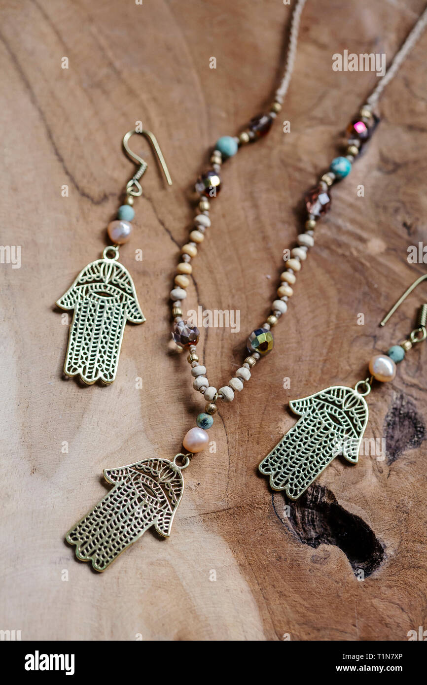 Hamsa Fatima hand metal pendant jewelry set on wooden background Stock ...