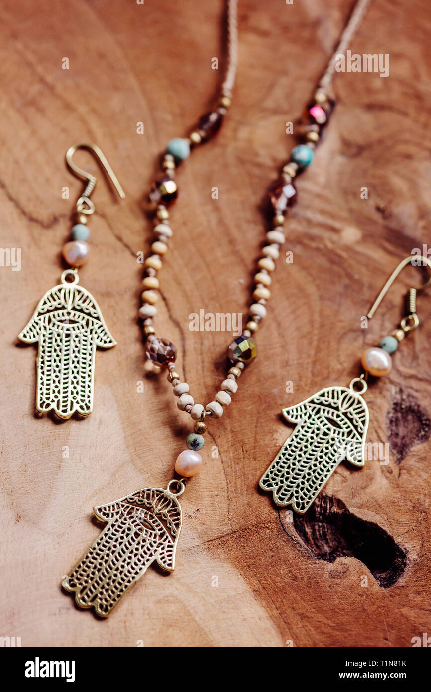 Hamsa Fatima hand metal pendant jewelry set on wooden background Stock ...