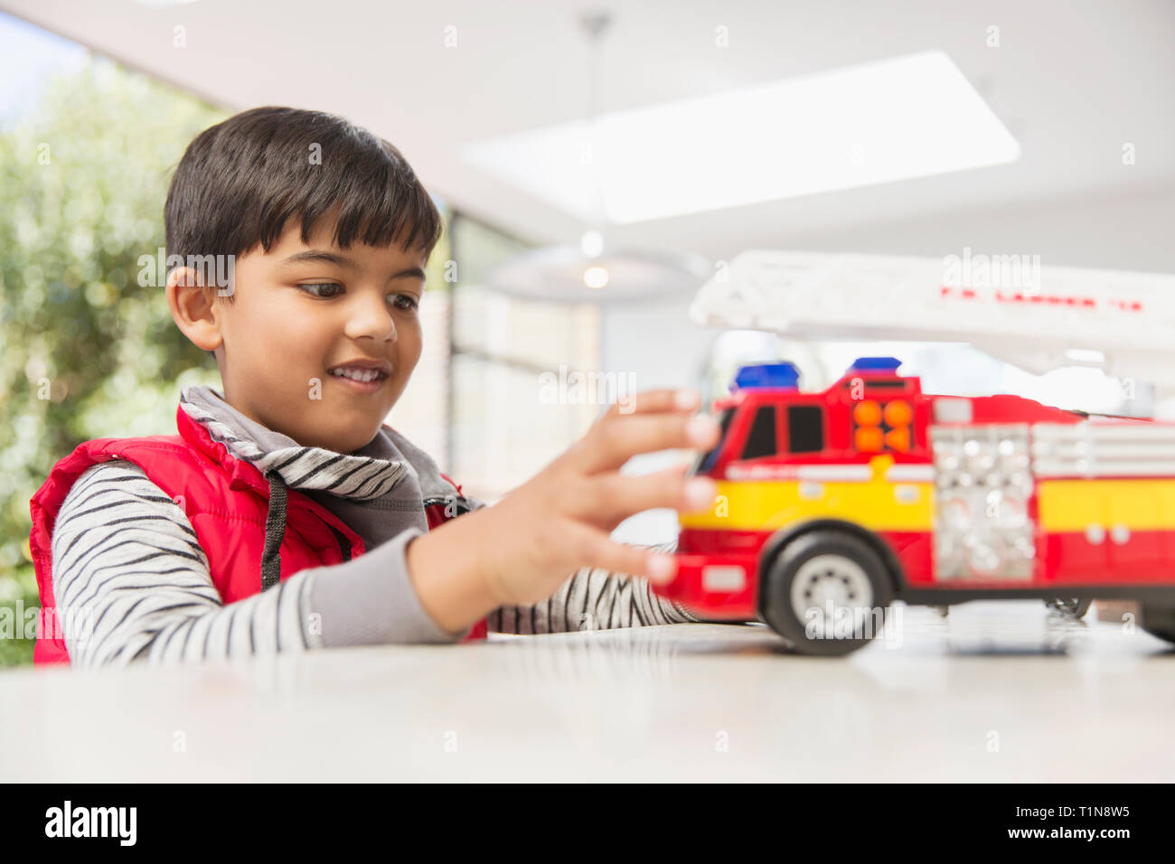 Boy playing with fire engine toy Stock Photo - Alamy