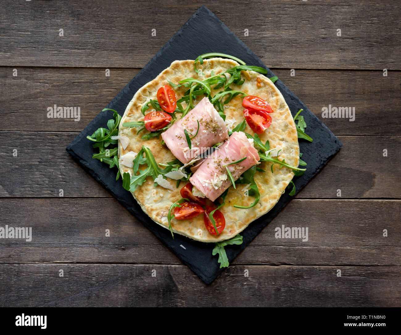 rolls of cooked ham stuffed with crescenza cheese on a bed of piadina ...