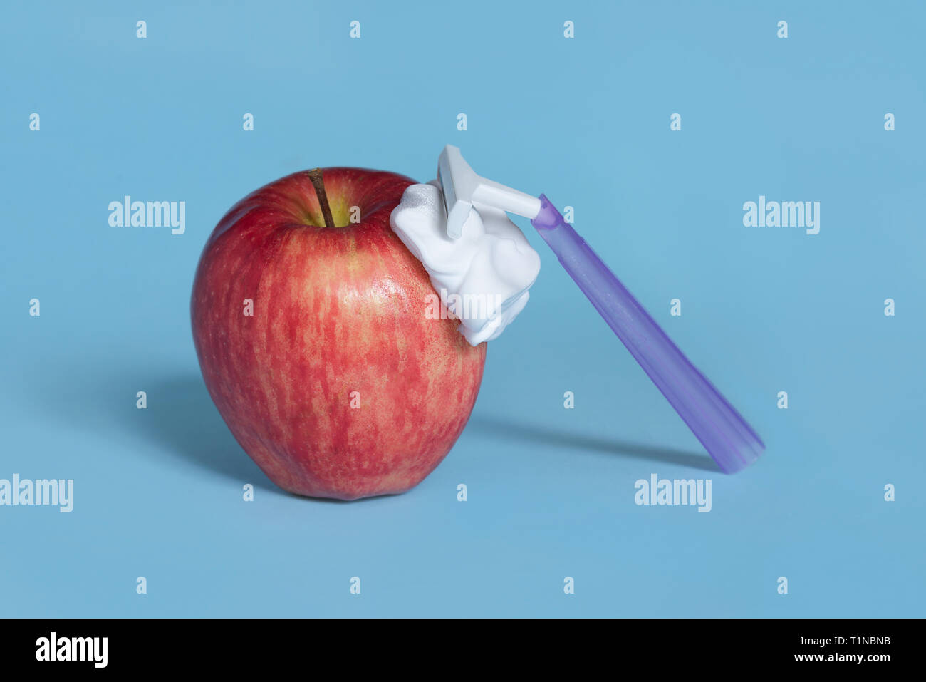 apple with shaving foam and disposable razor as a concept for gentle ...