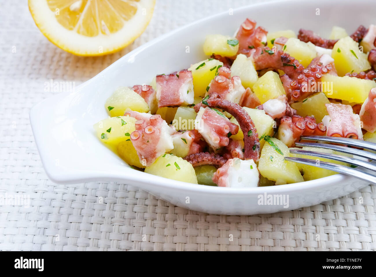 Octopus cut into small pieces and prepared with potatoes and parsley ...