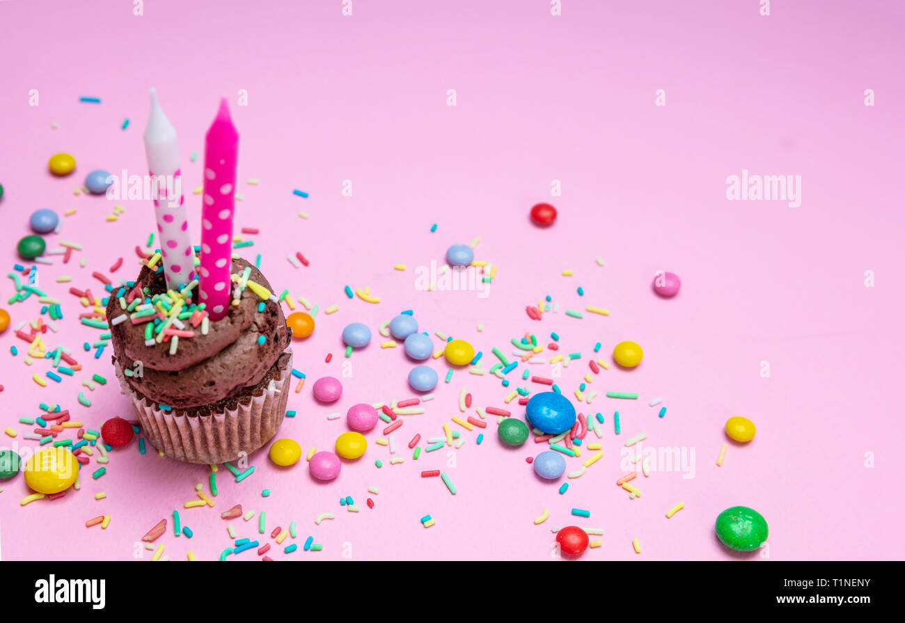 Girl birthday. Cupcake chocolate with two candles on pink pastel ...