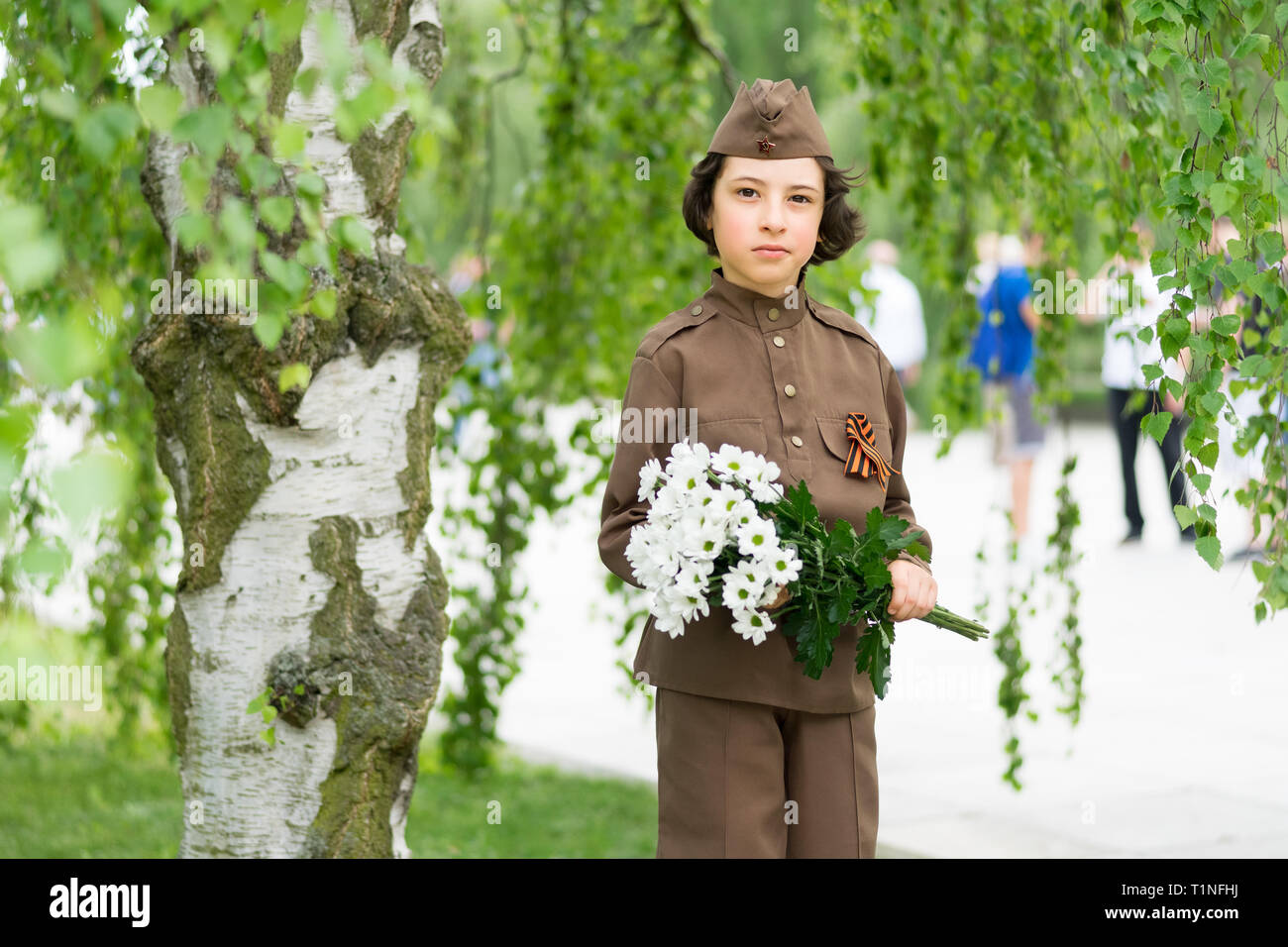 Portrait of a boy with flowers, in the uniform of a soldier of the Red ...