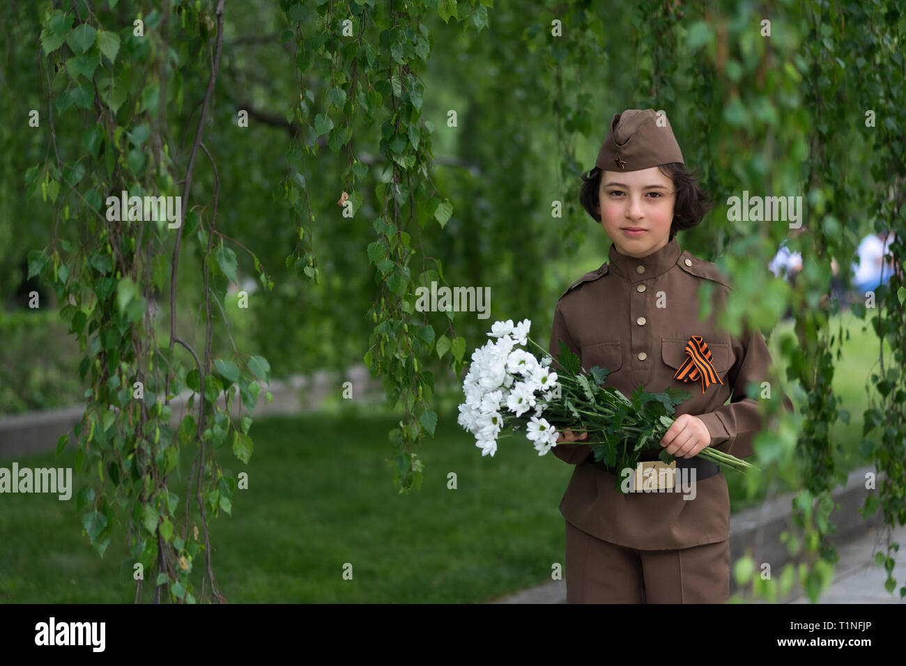 Portrait of a boy with flowers, in the uniform of a soldier of the Red ...