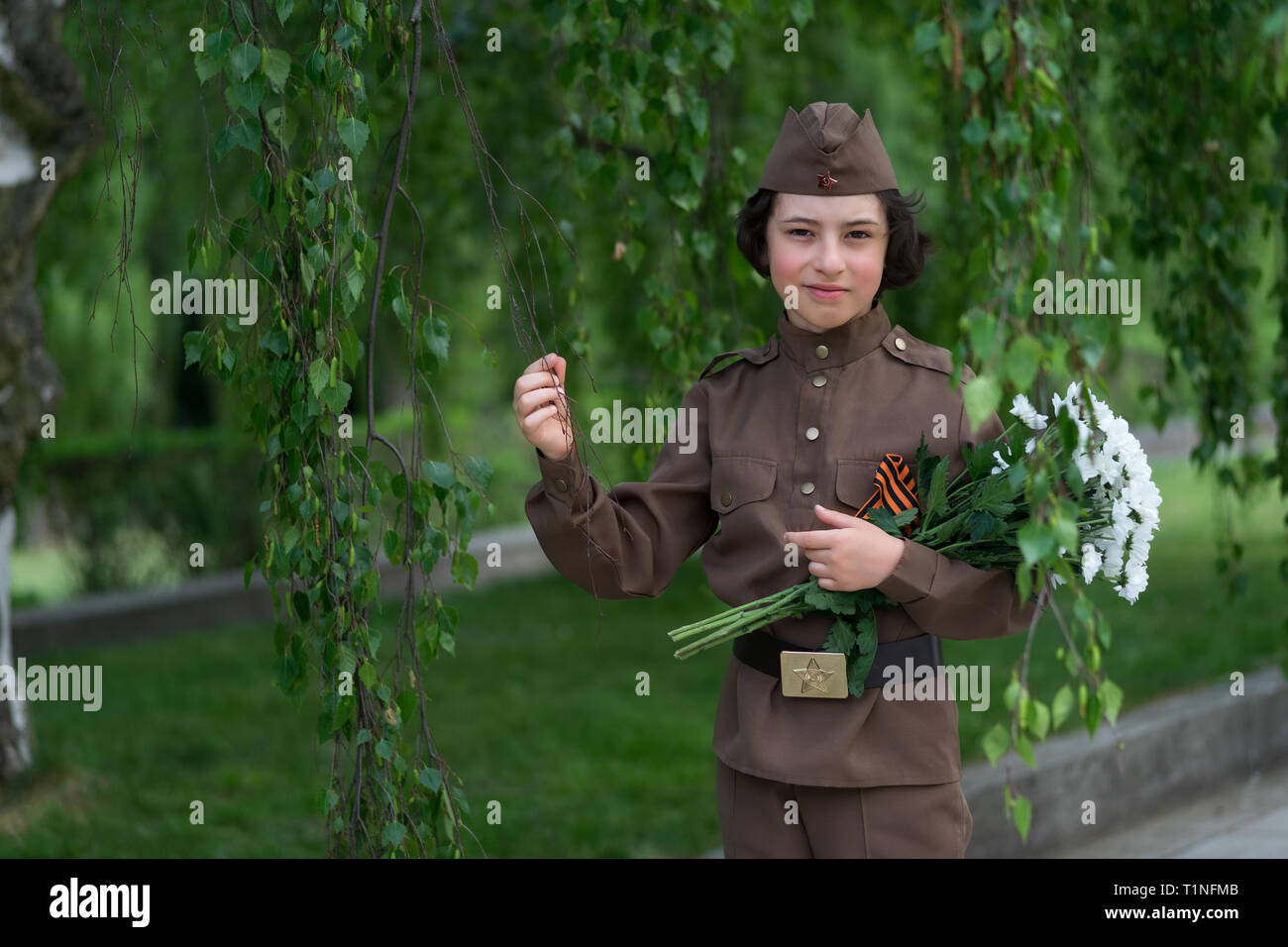 Portrait of a boy with flowers, in the uniform of a soldier of the Red ...