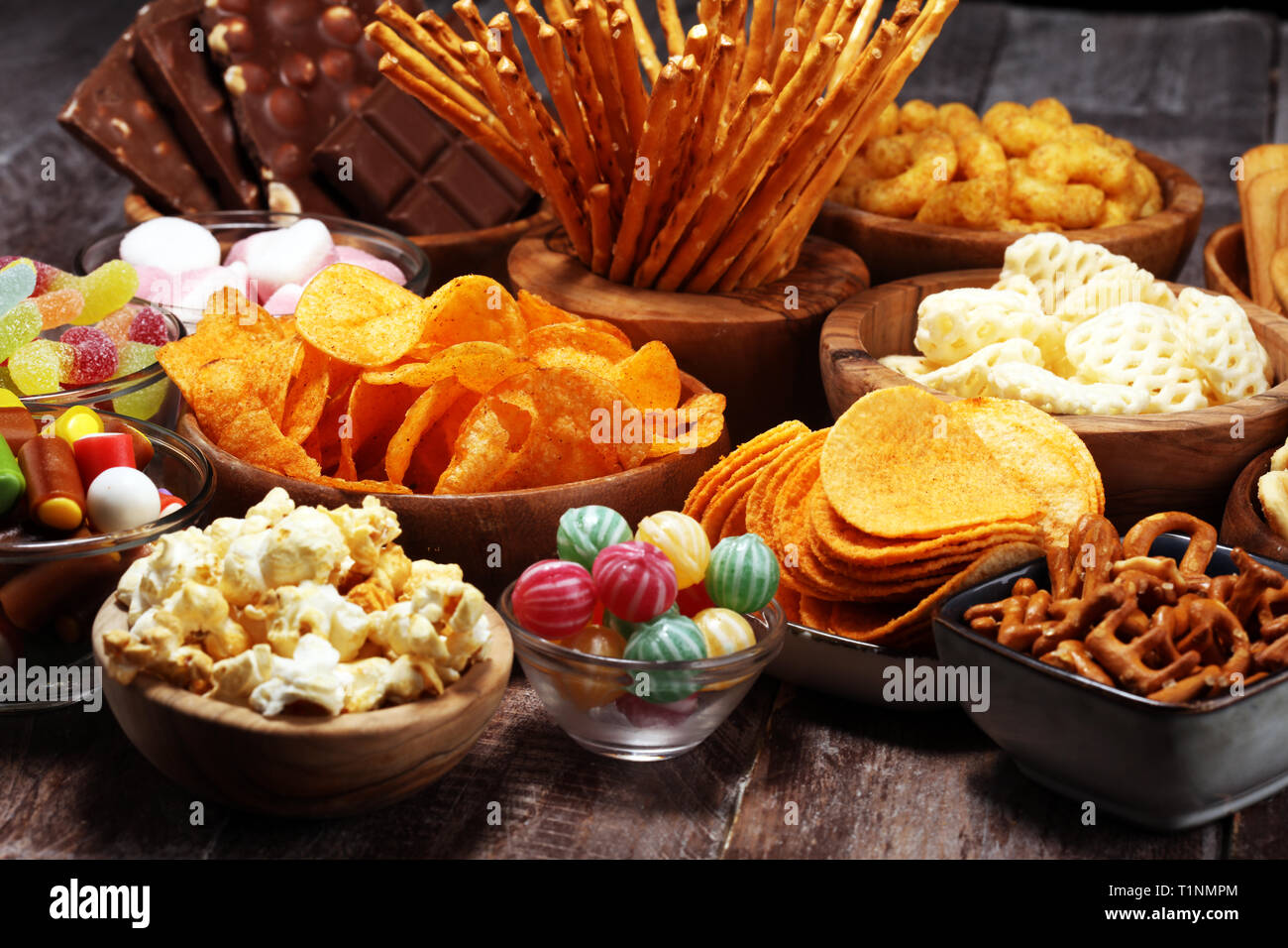 Salty snacks. Pretzels, chips, crackers in wooden bowls. Unhealthy ...