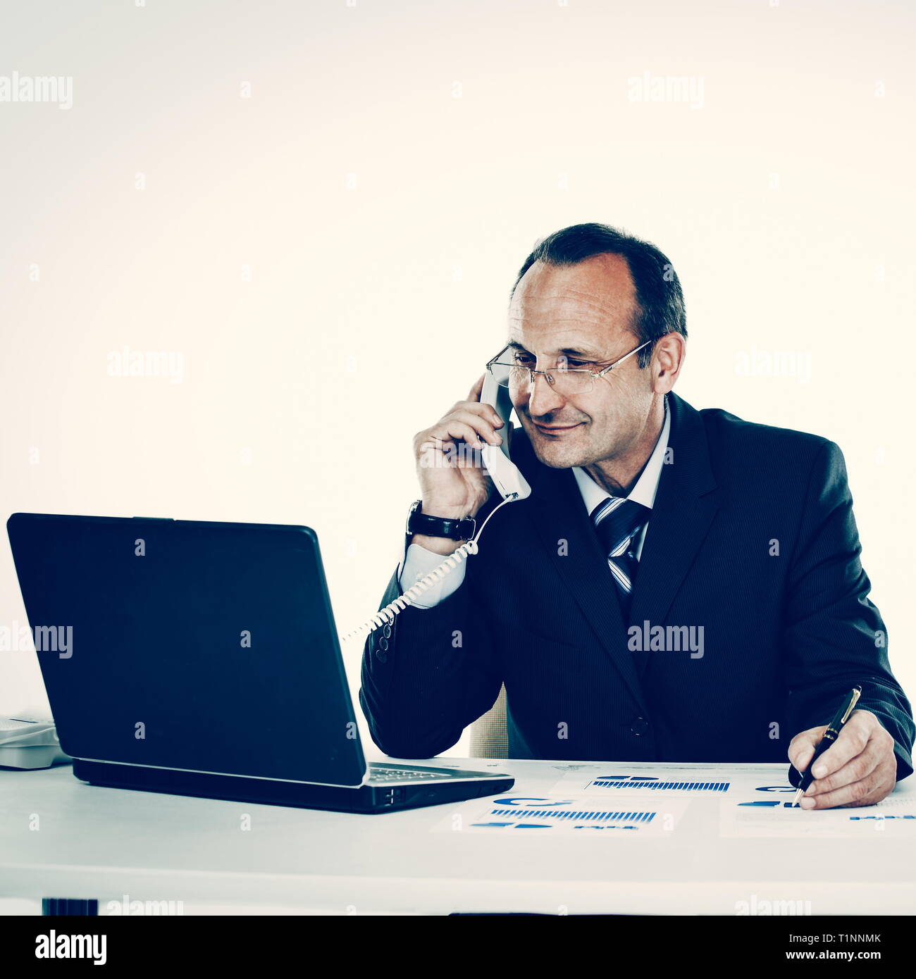 Confident businessman in the workplace in the office of a laptop ...