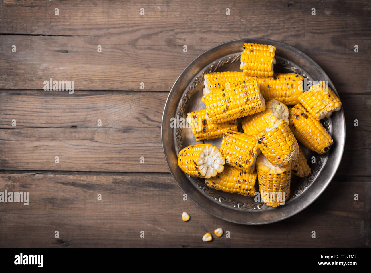 Grilled corn cobs on the brown rustic background with copy space ...