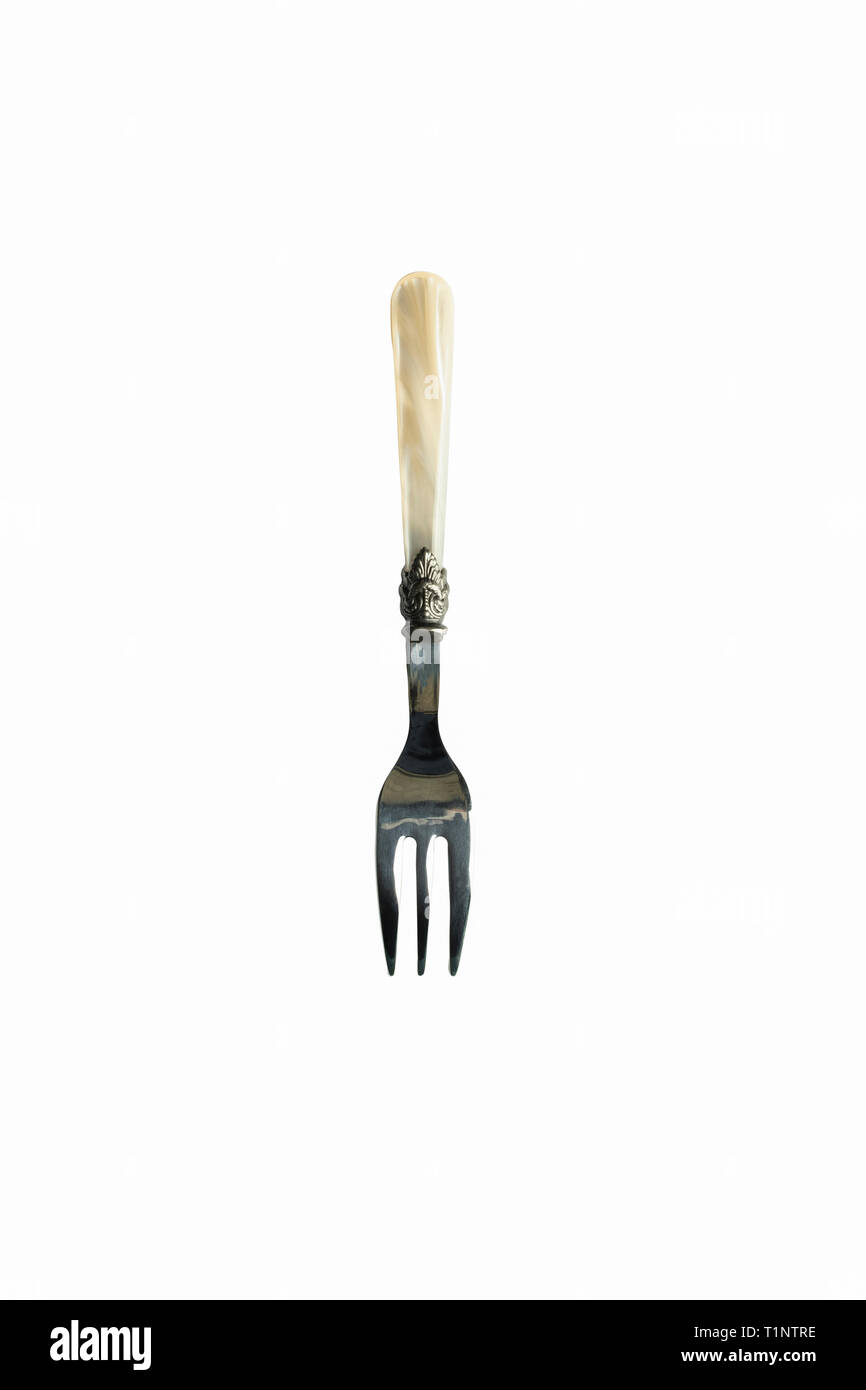 Shiny metal fork with pattern and beige handle. View from above ...