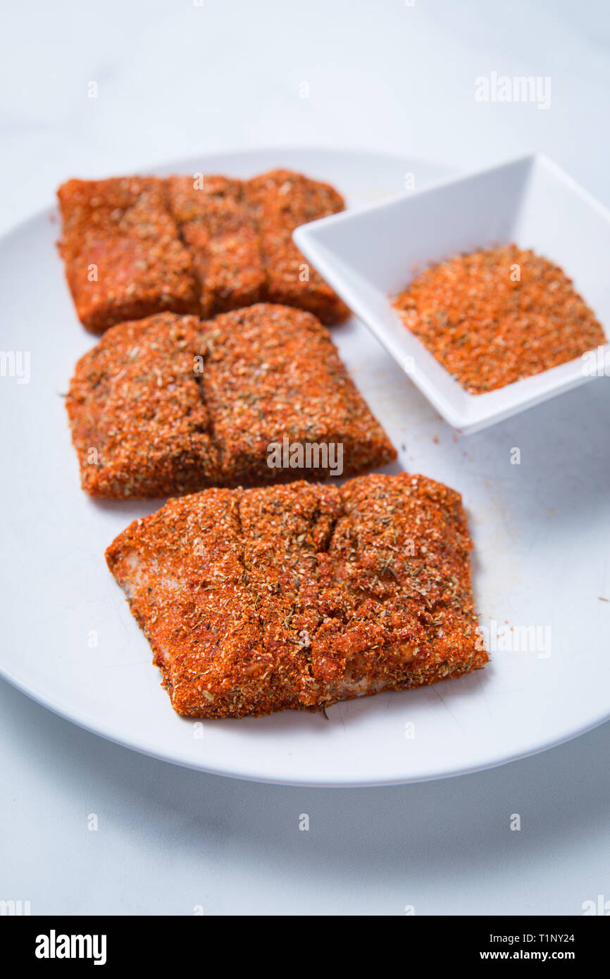 Blackened spicy fish with red spice rub on top of fish filets. Spiced ...