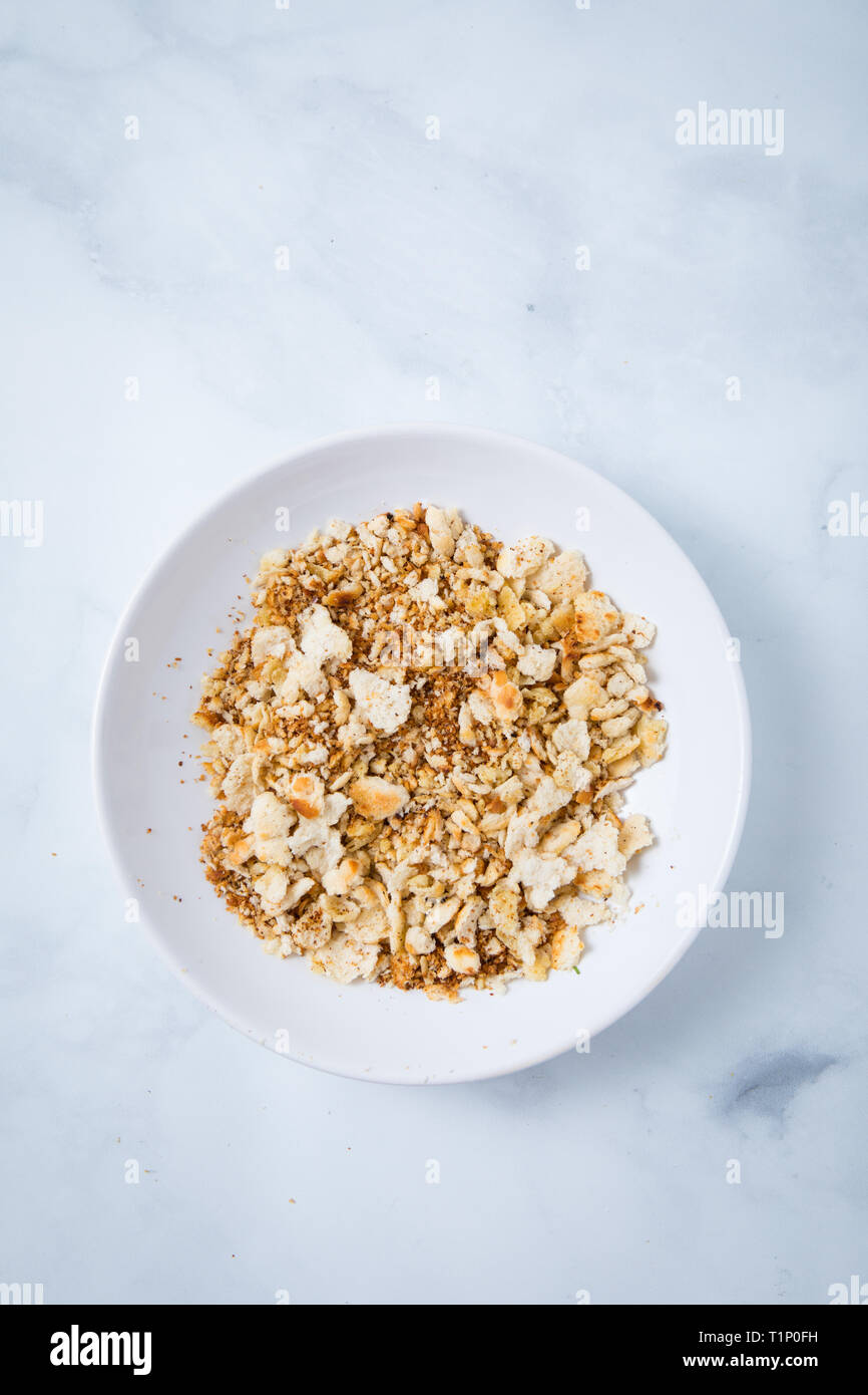 Toasted and fried breadcrumbs recipe in a white plate in the center and ...