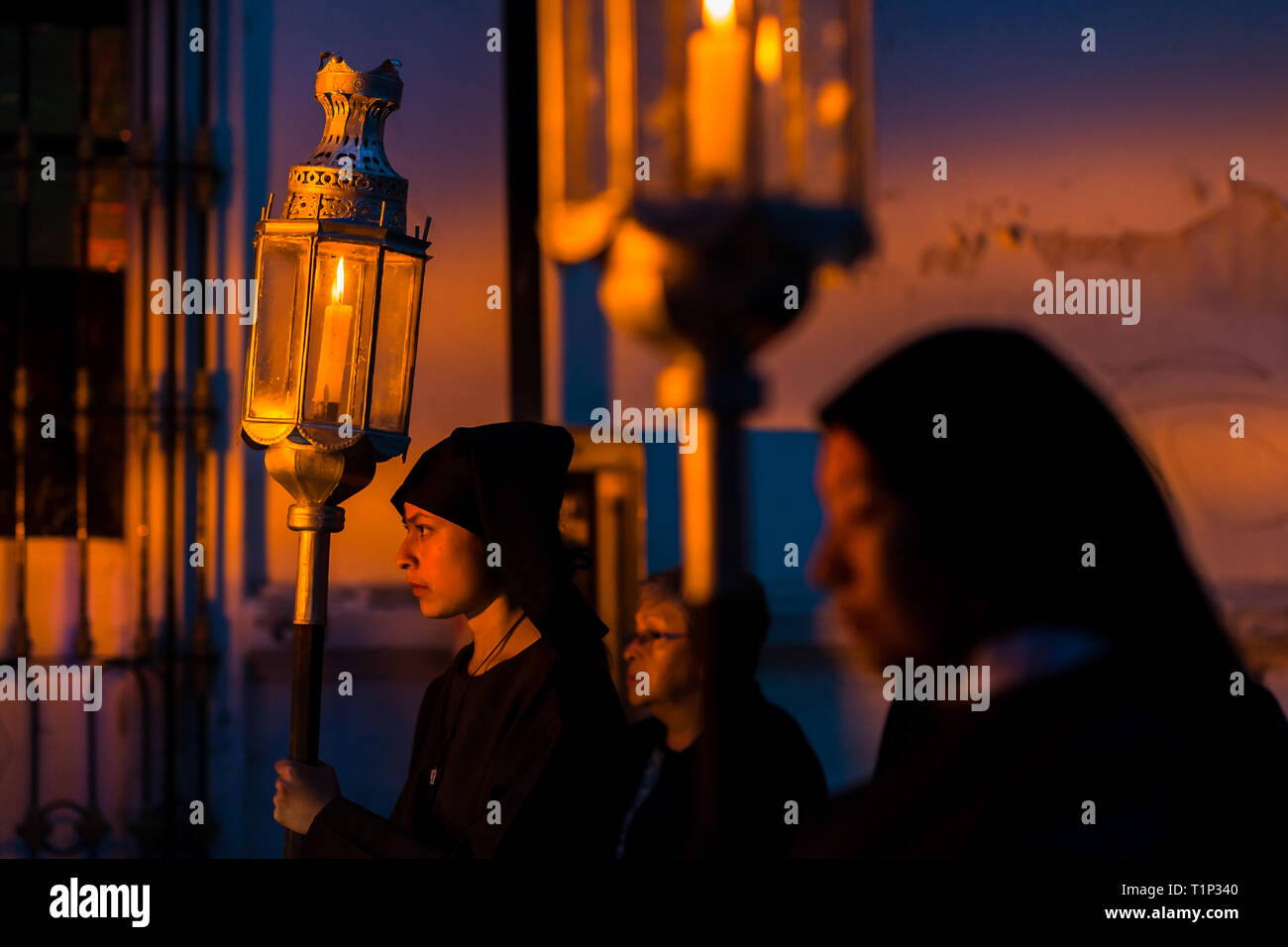 Catholic nuns, carrying procession lamps, walk in the Holy week ...