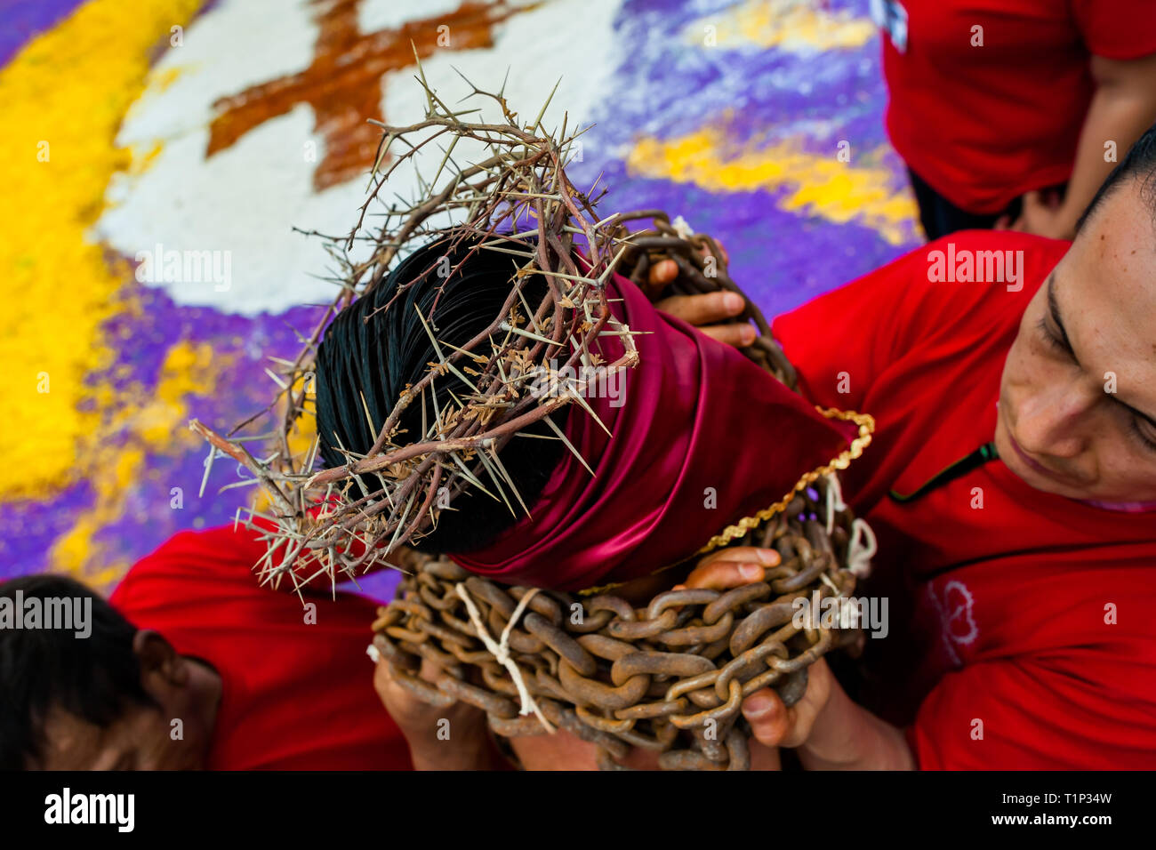 A chained Catholic penitent, wearing a crown of thorns, is seen while ...