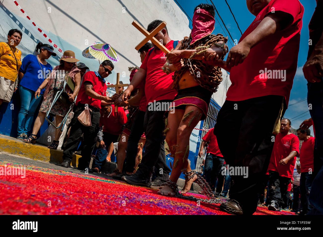 A hooded Catholic penitent, wearing heavy chains and cactus spines ...