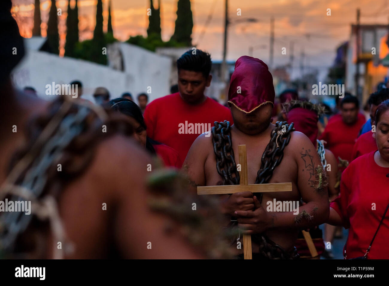 A hooded Catholic penitent, wearing chains and cactus spines stuck to ...