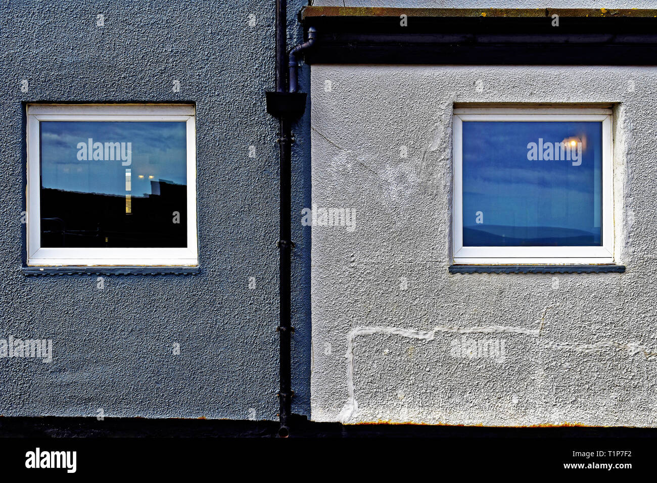 Two grey pebble dashed walls with square windows Stock Photo - Alamy