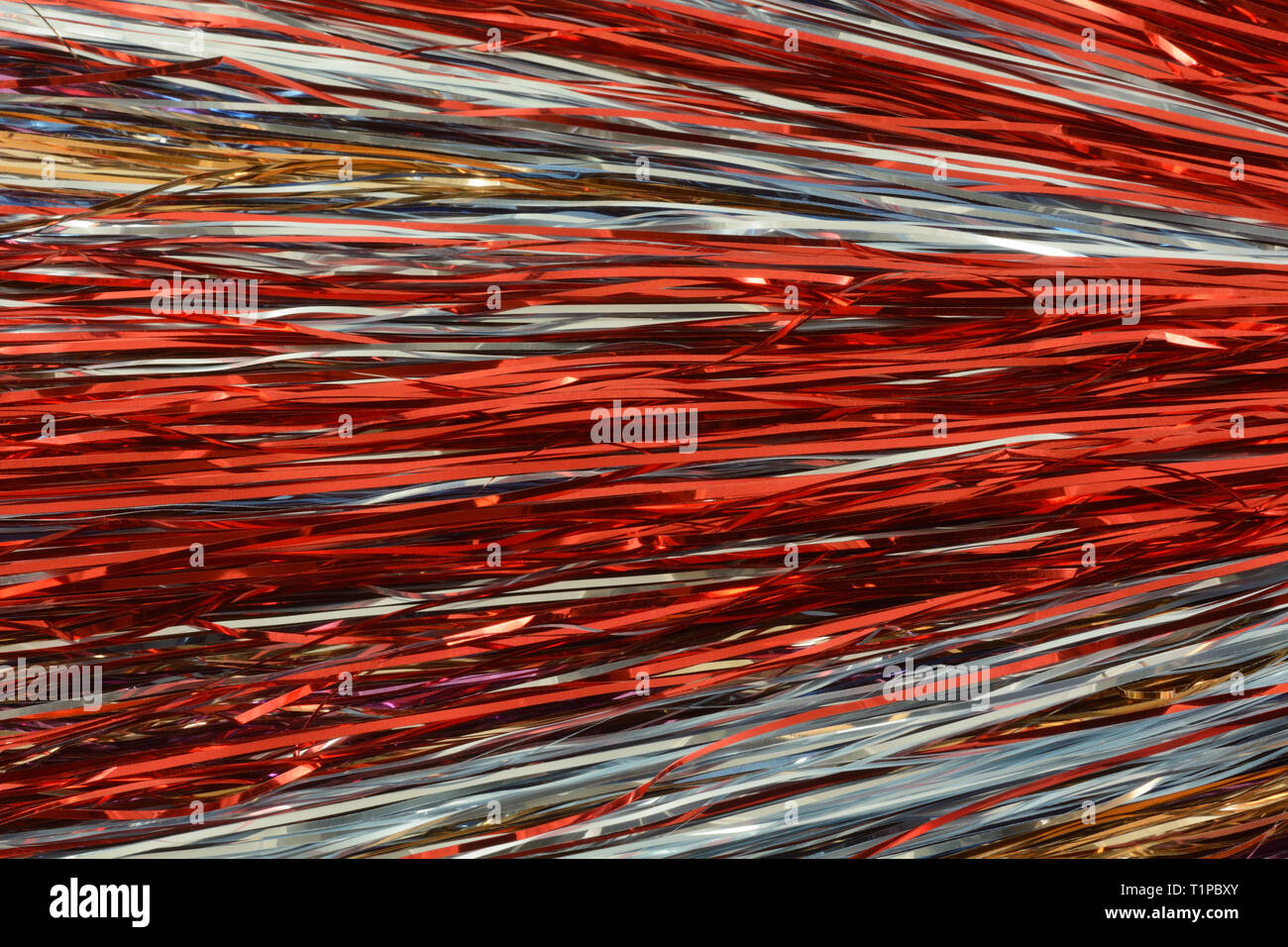 Abstract festive celebration red, gold, blue explosive streamer tinsel ...