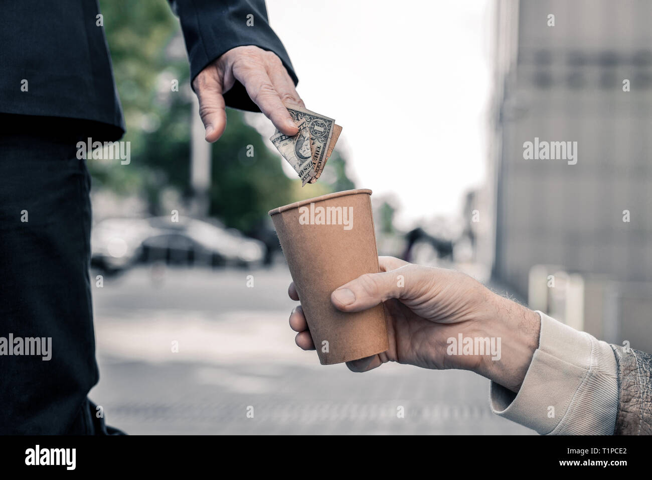 Rich business man stopping on street and compassionately sharing money ...