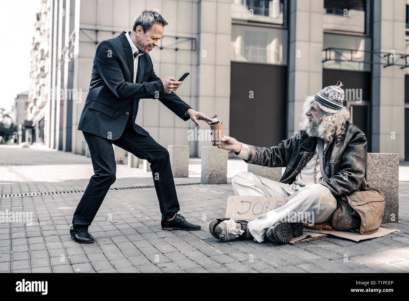Vain rich man making selfie of himself with dirty homeless Stock Photo ...