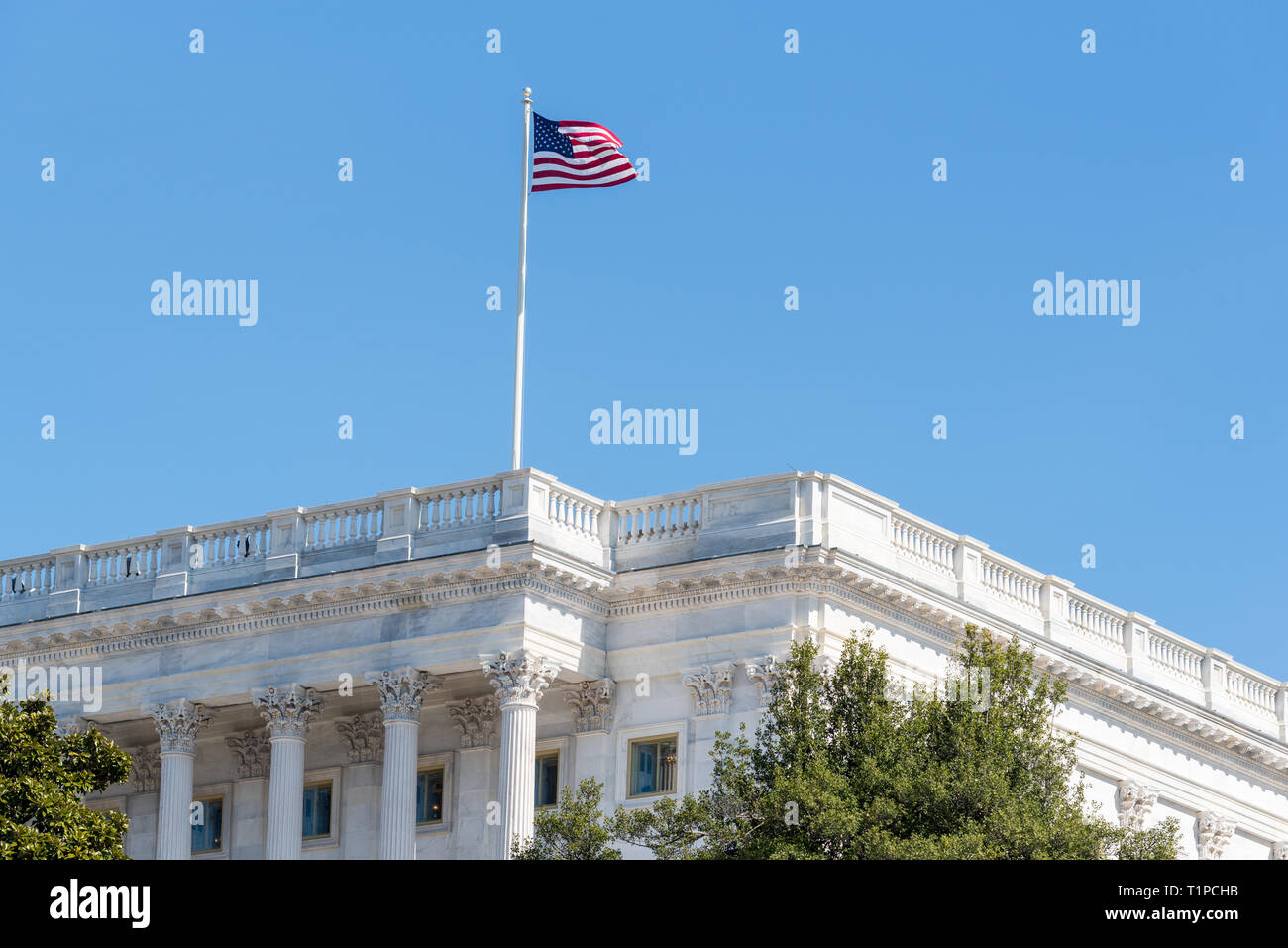 American flag flying from roof of Senate wing of US Capitol Building in ...