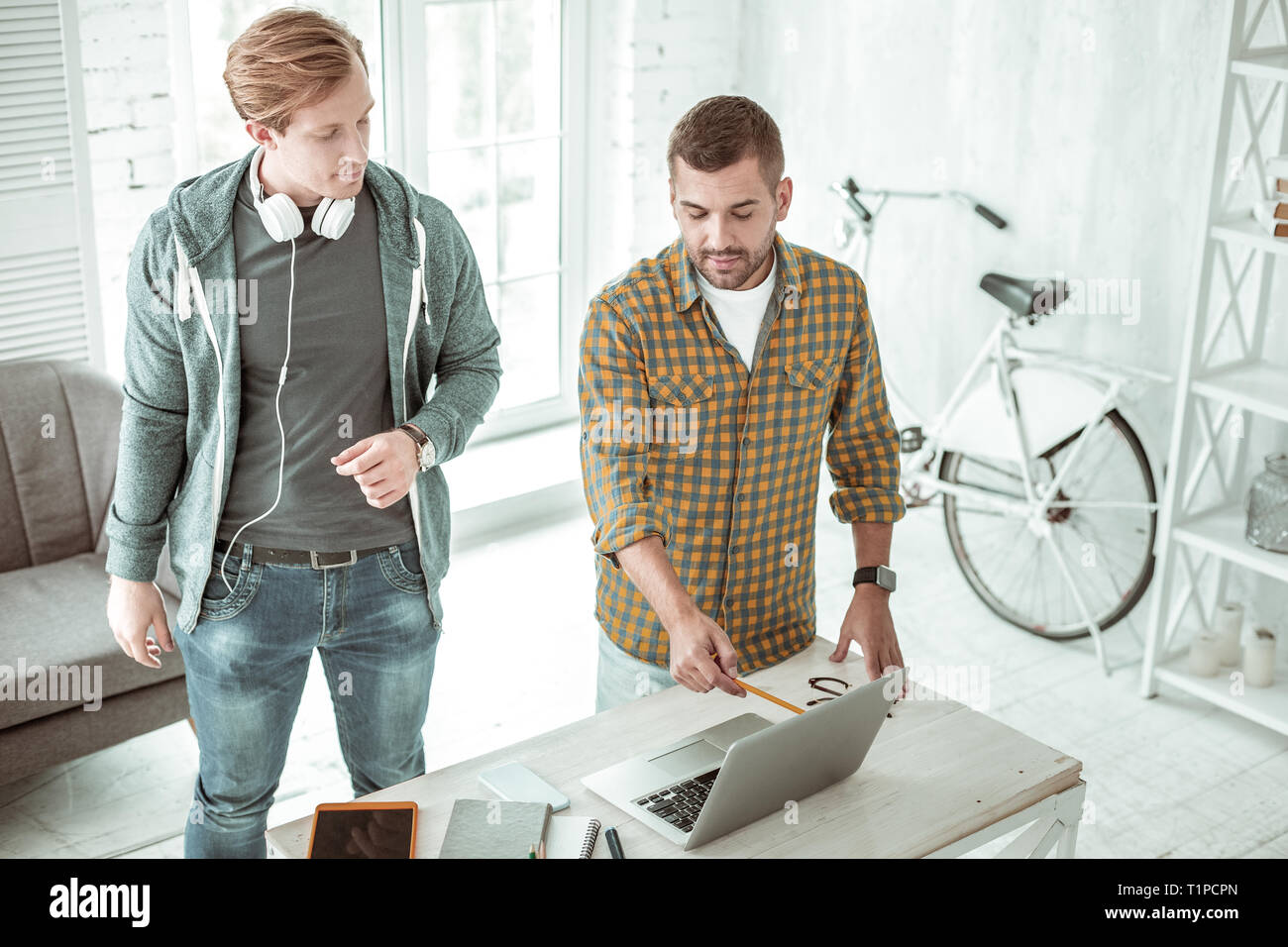 Nice handsome man pointing at the laptop screen Stock Photo - Alamy