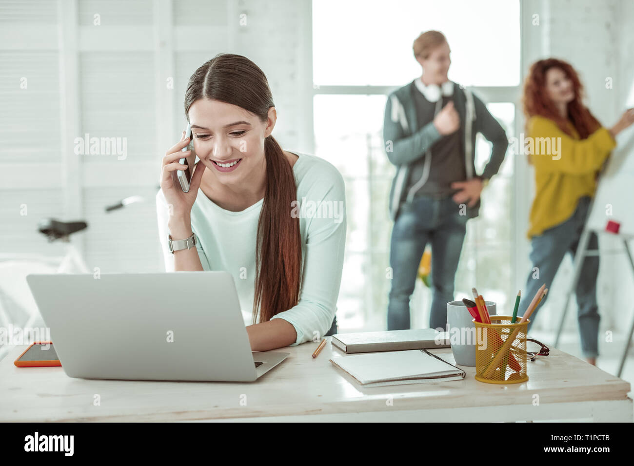 Nice happy woman answering the phone call Stock Photo - Alamy