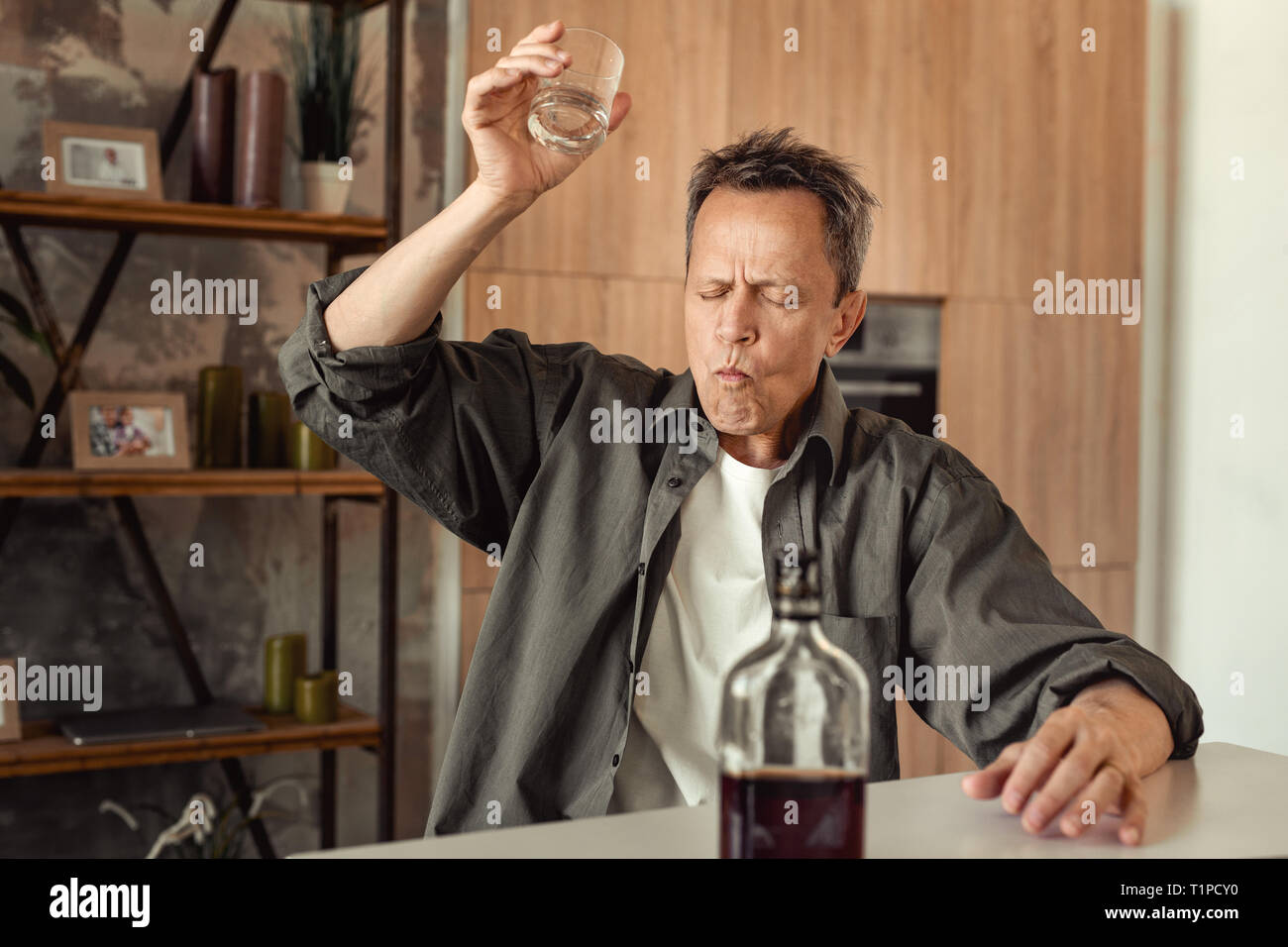 Resolute short-haired battered man ruining his life with alcohol Stock ...