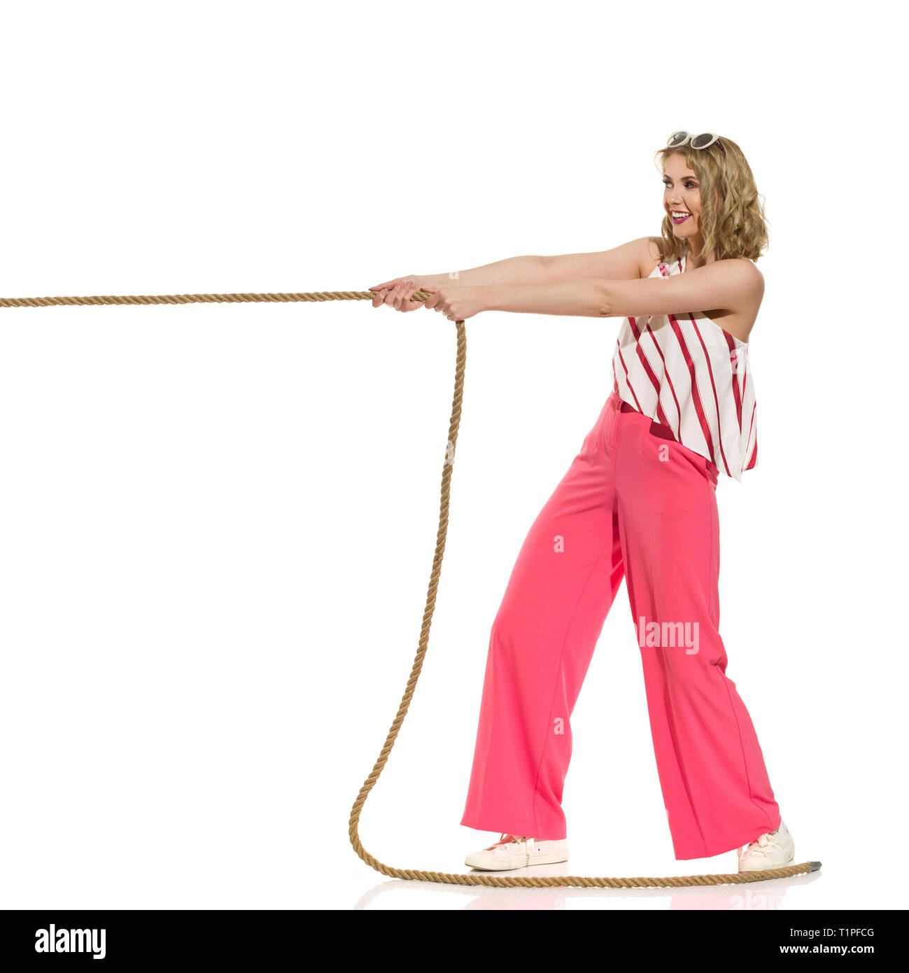 Smiling woman pulling rope on hi-res stock photography and images - Alamy