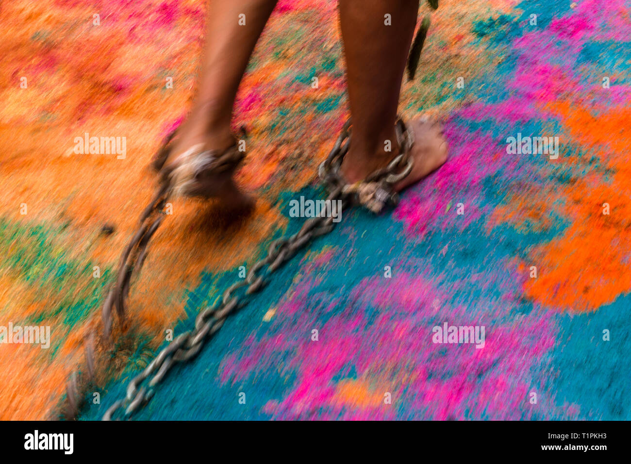 A Catholic devotee, with cactus spines stuck to his leg, drags chains ...