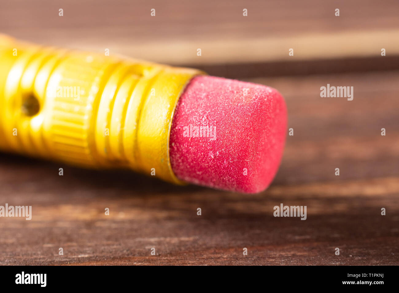Closeup of one piece of yellow pencil cup eraser on brown wood Stock ...