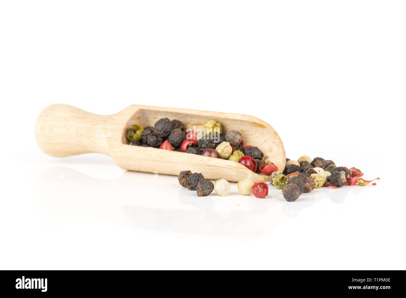 Lot of whole peppercorns of four colors with wooden scoop isolated on ...