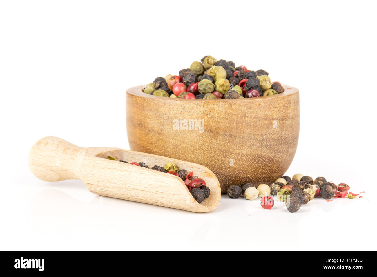Lot of whole peppercorns of four colors with wooden bowl and wooden ...