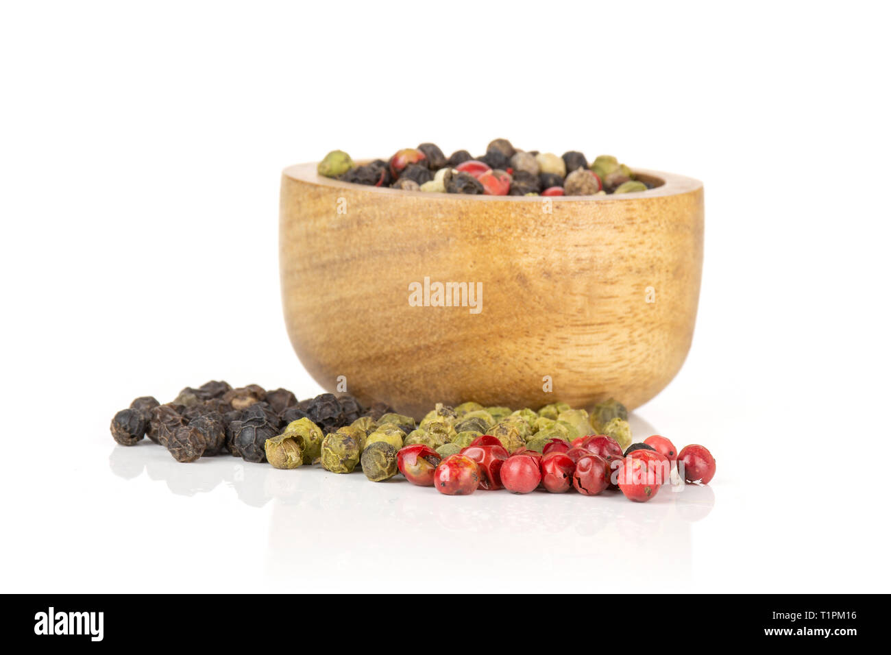 Lot of whole peppercorns of four colors with wooden bowl isolated on ...