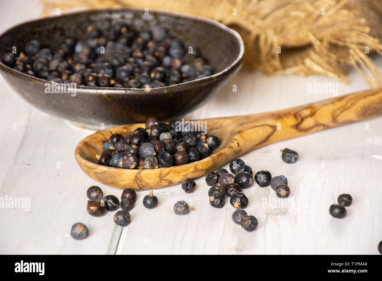Lot of whole dry juniper berry seed on white wood Stock Photo - Alamy