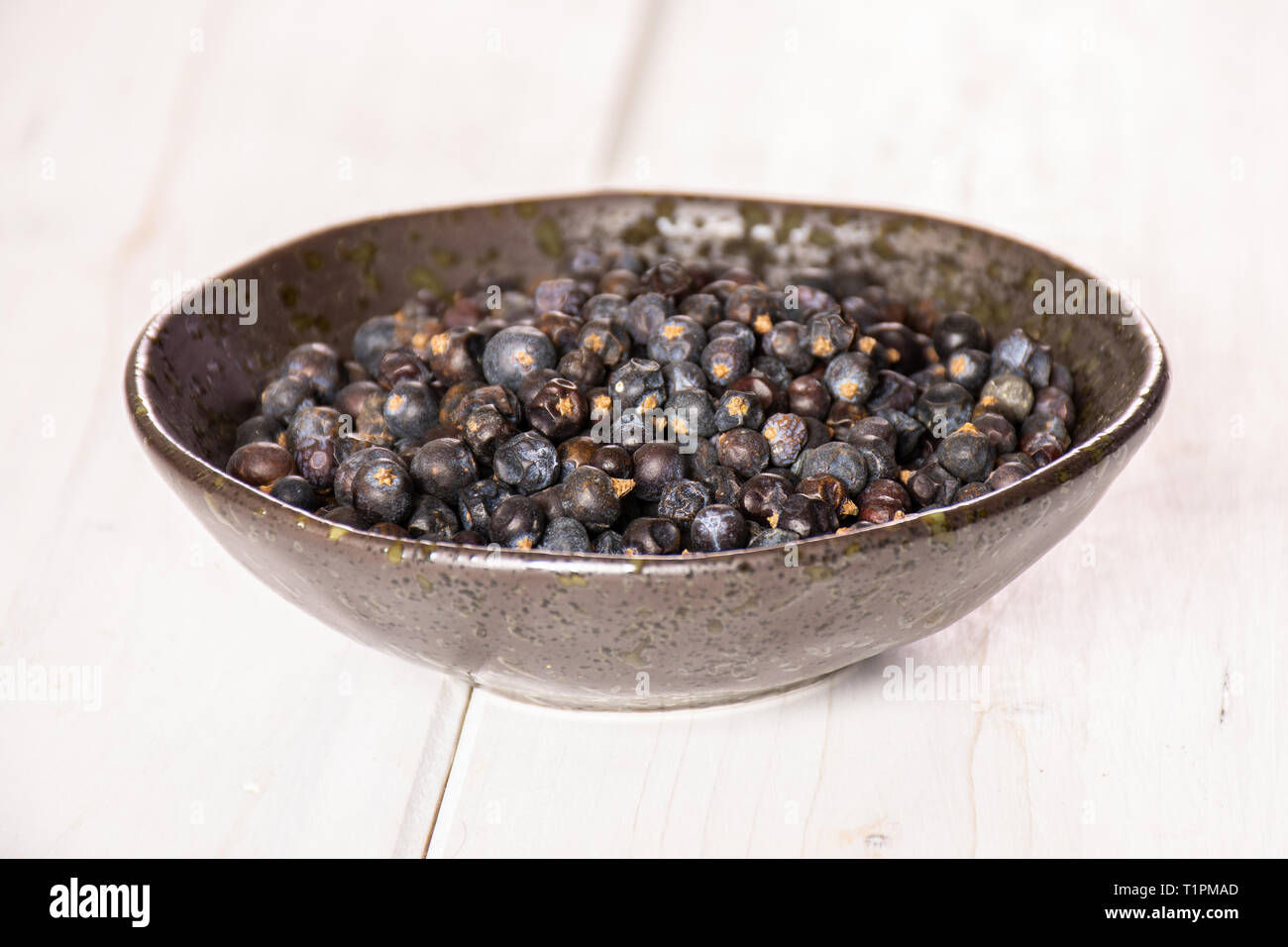 Lot of whole dry juniper berry seed on white wood Stock Photo - Alamy