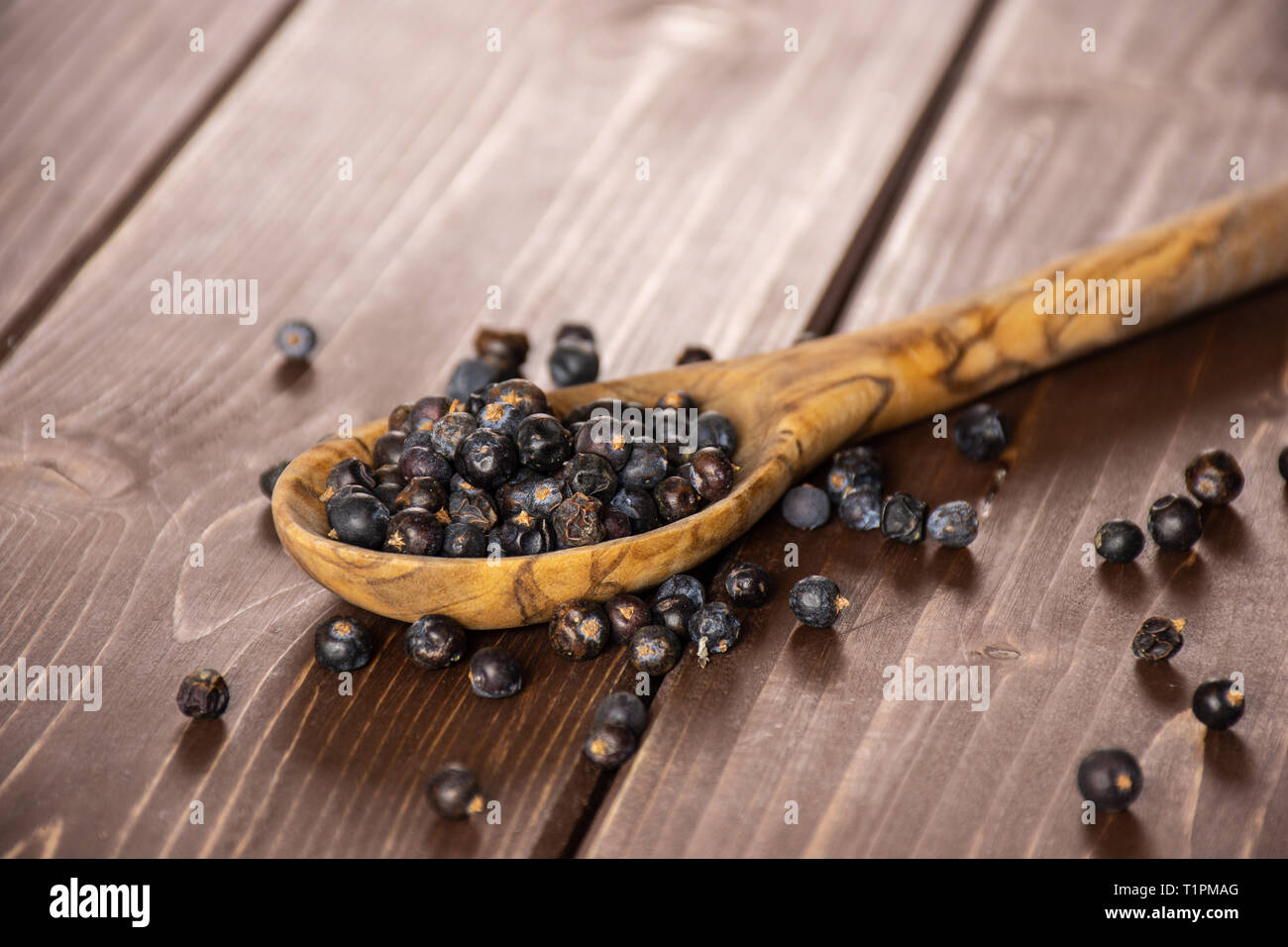 Lot of whole dry juniper berry seed on brown wood Stock Photo - Alamy