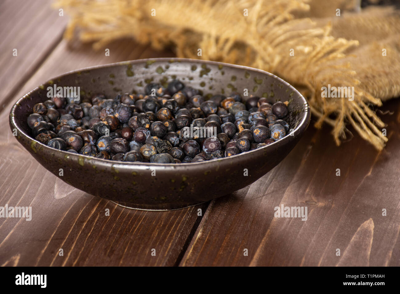 Lot of whole dry juniper berry seed on brown wood Stock Photo - Alamy