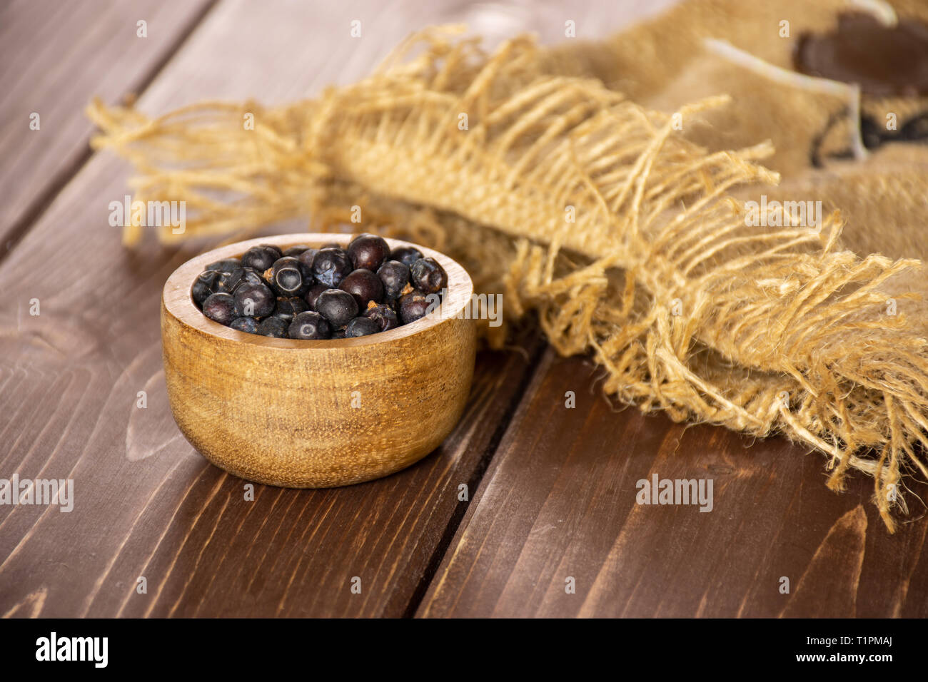Lot of whole dry juniper berry seed on brown wood Stock Photo - Alamy