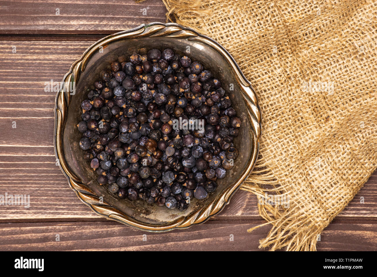 Lot of whole dry juniper berry seed flatlay on brown wood Stock Photo ...