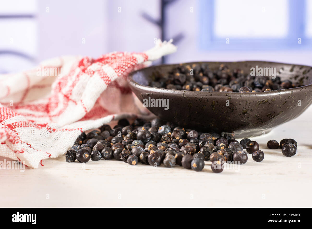 Lot of whole dry juniper berry seed with blue window in background ...