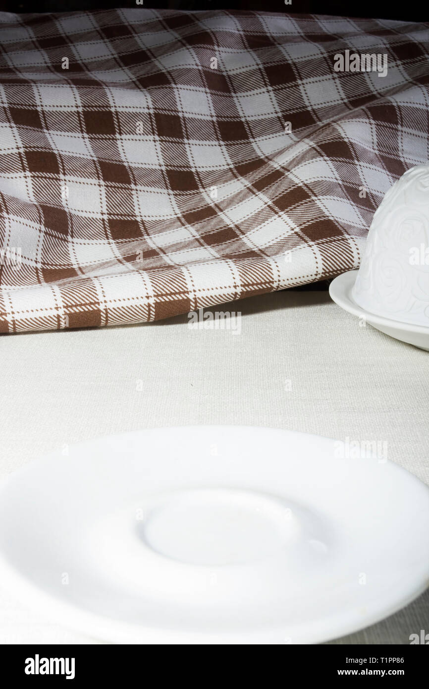 Dining table with dishes and checkered napkin Stock Photo - Alamy