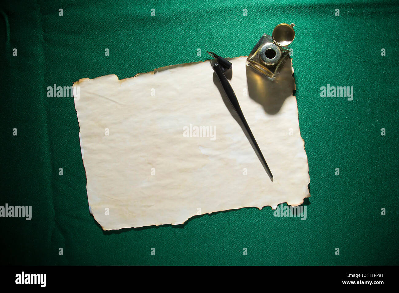 Paper, quill and inkwell on a table with green cloth Stock Photo - Alamy