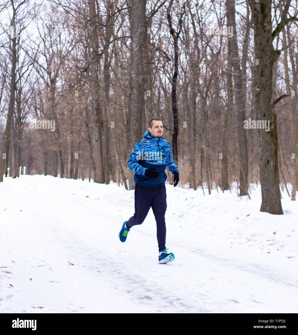 Man running in the winter forest with a lot of snow Stock Photo - Alamy